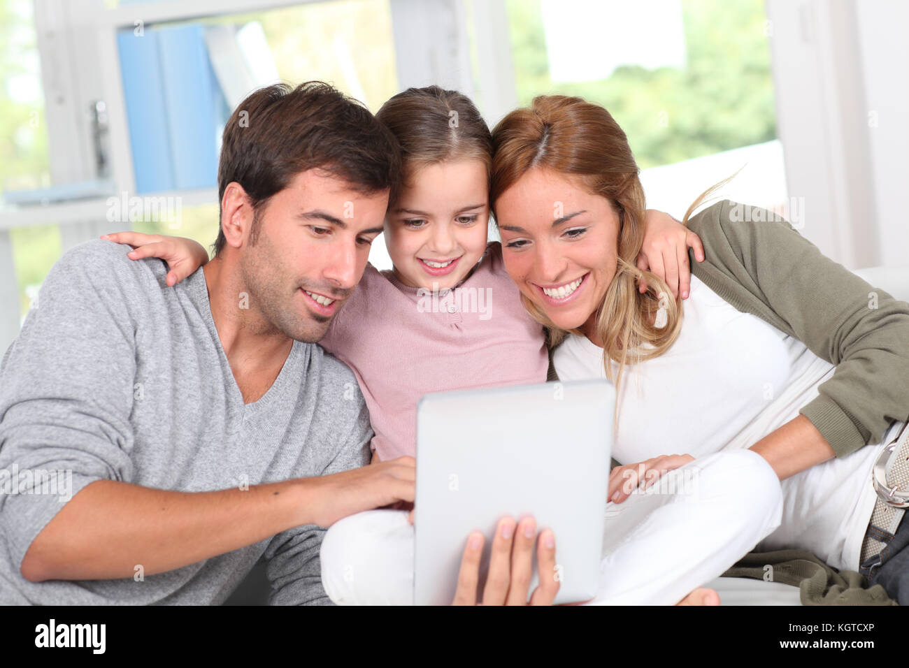 Family using electronic tablet at home Stock Photo - Alamy