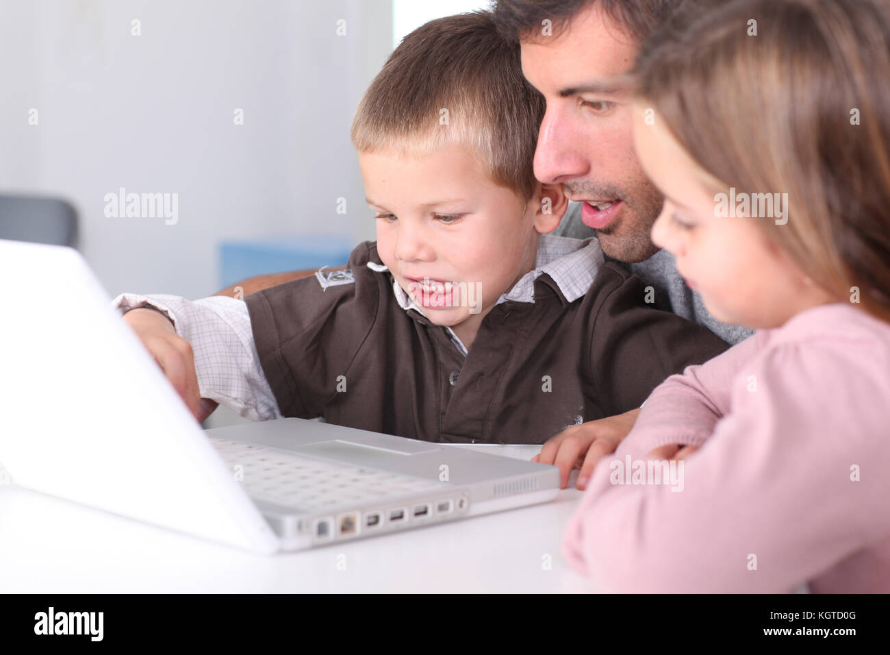 Man teaching kids how to use laptop computer Stock Photo - Alamy