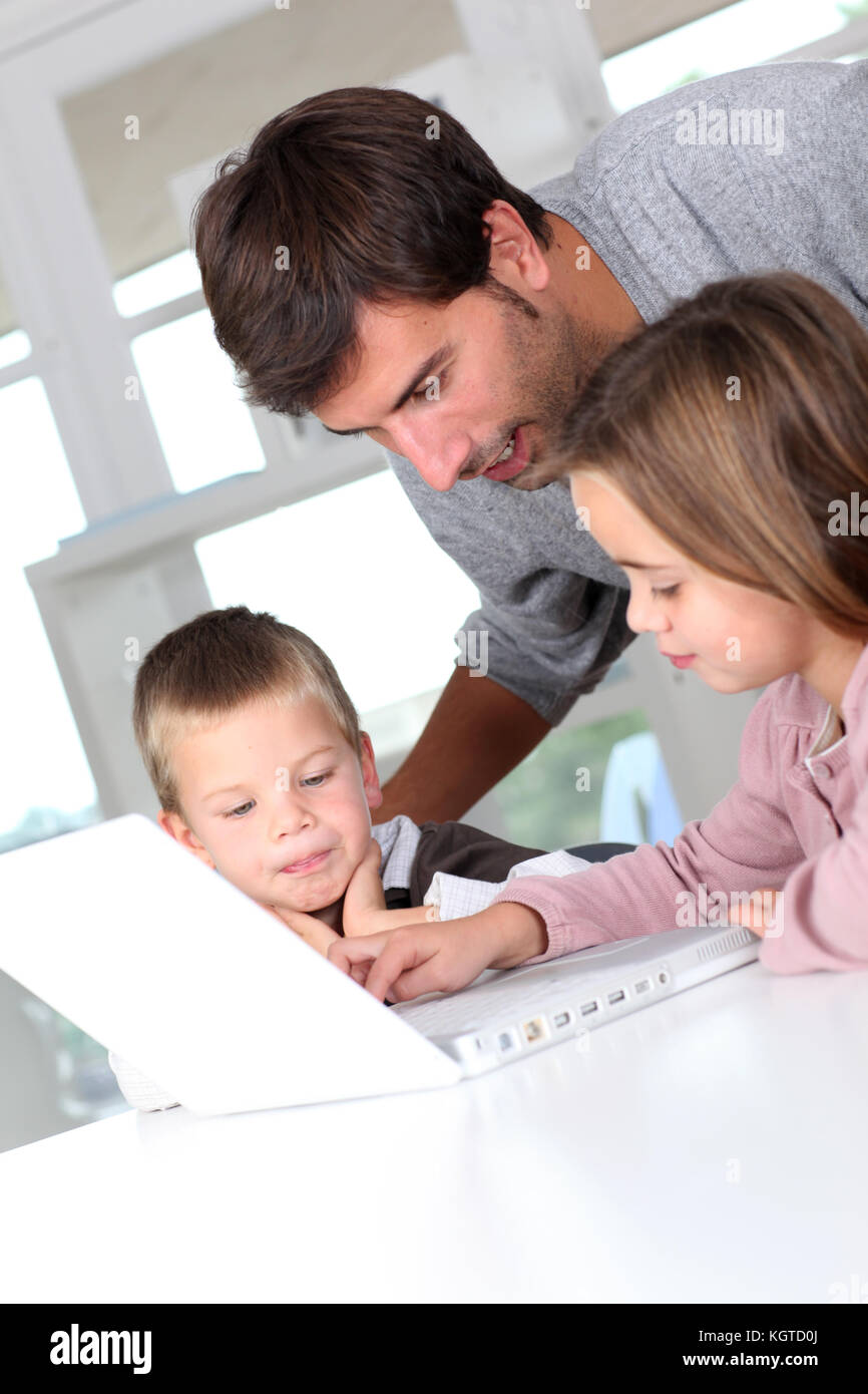 Man teaching kids how to use laptop computer Stock Photo - Alamy
