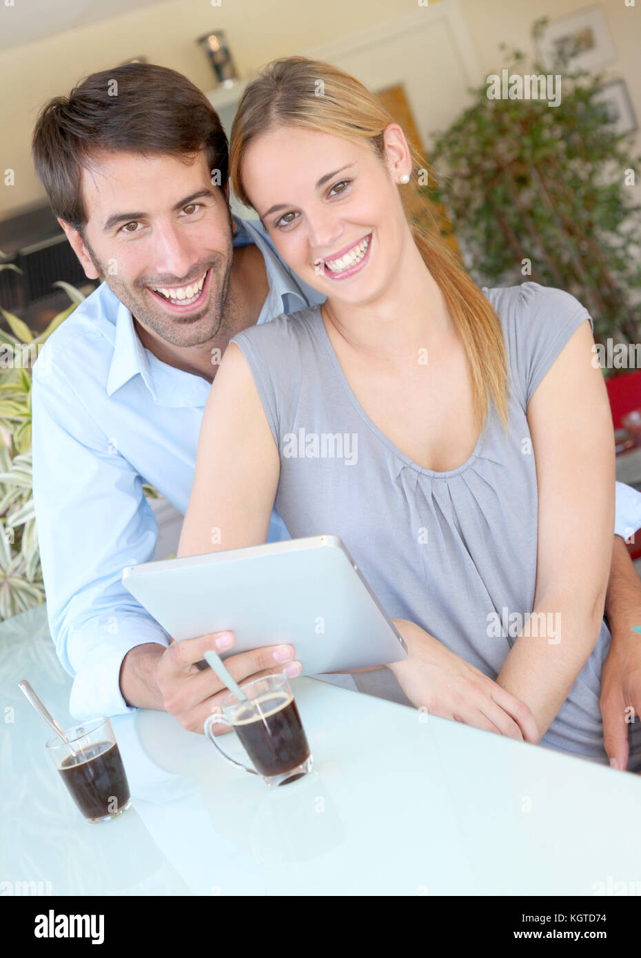 Happy young couple at home using electronic tablet Stock Photo - Alamy