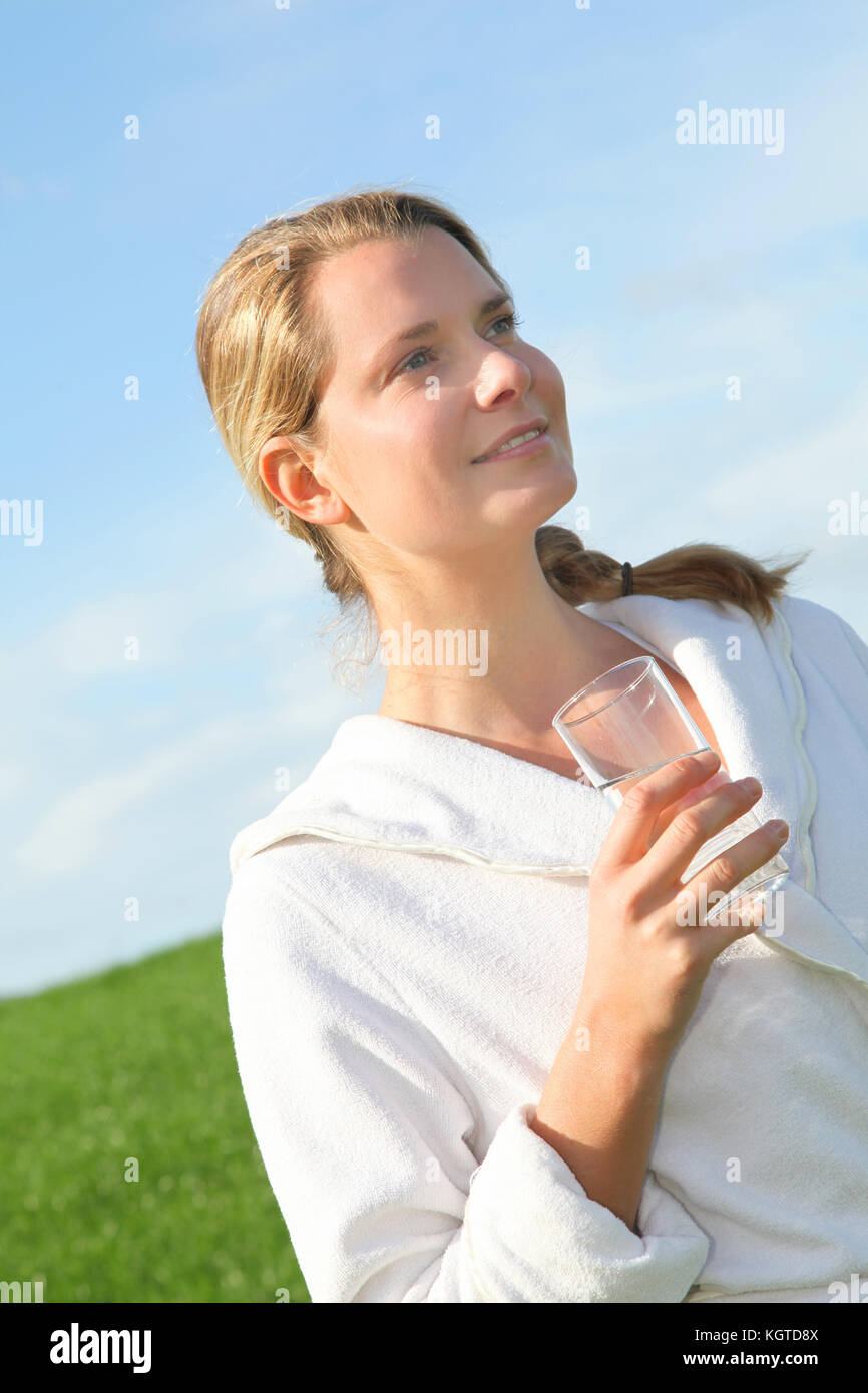 Woman drinking natural water in green field Stock Photo - Alamy