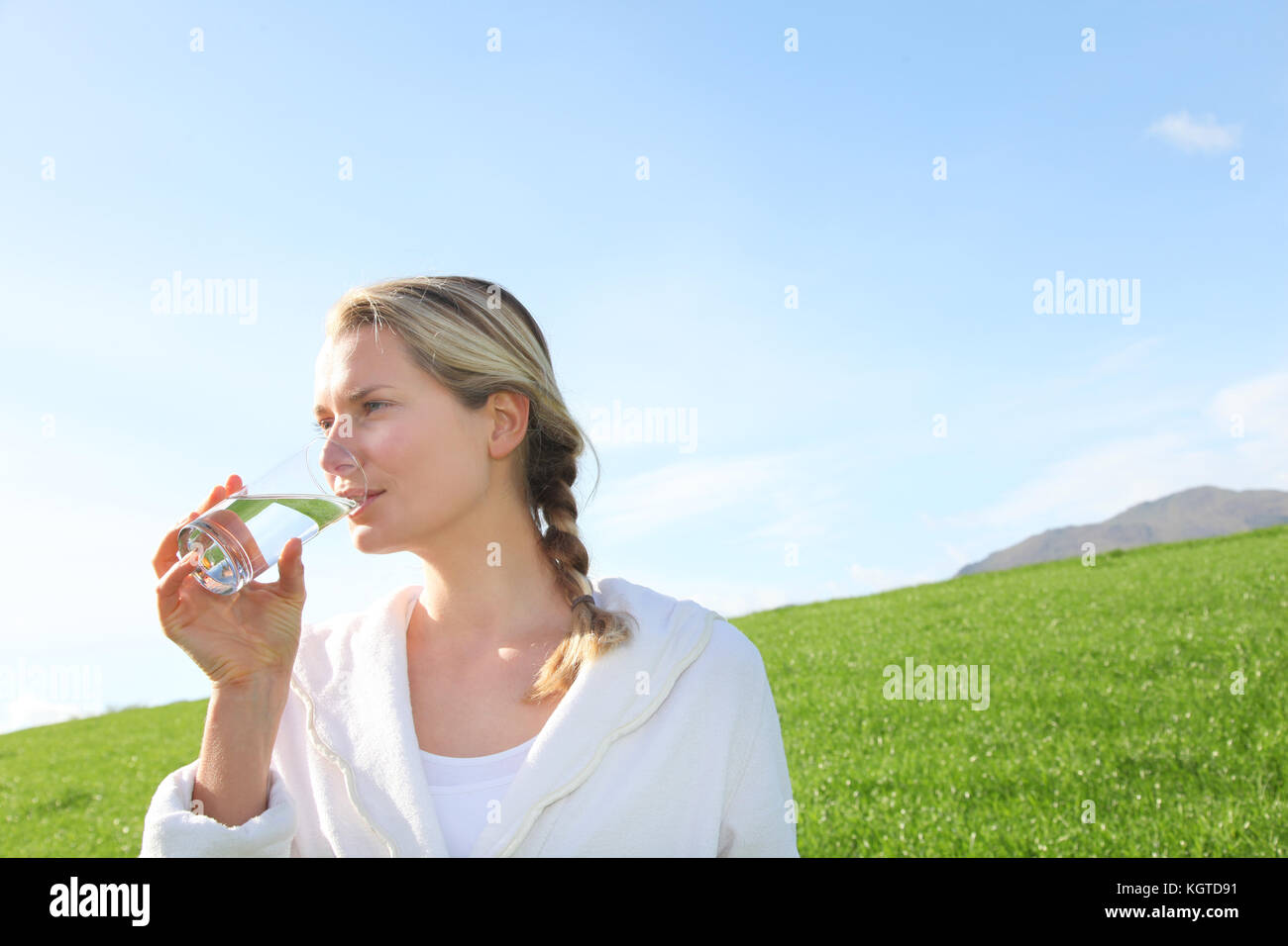 Woman drinking natural water in green field Stock Photo - Alamy