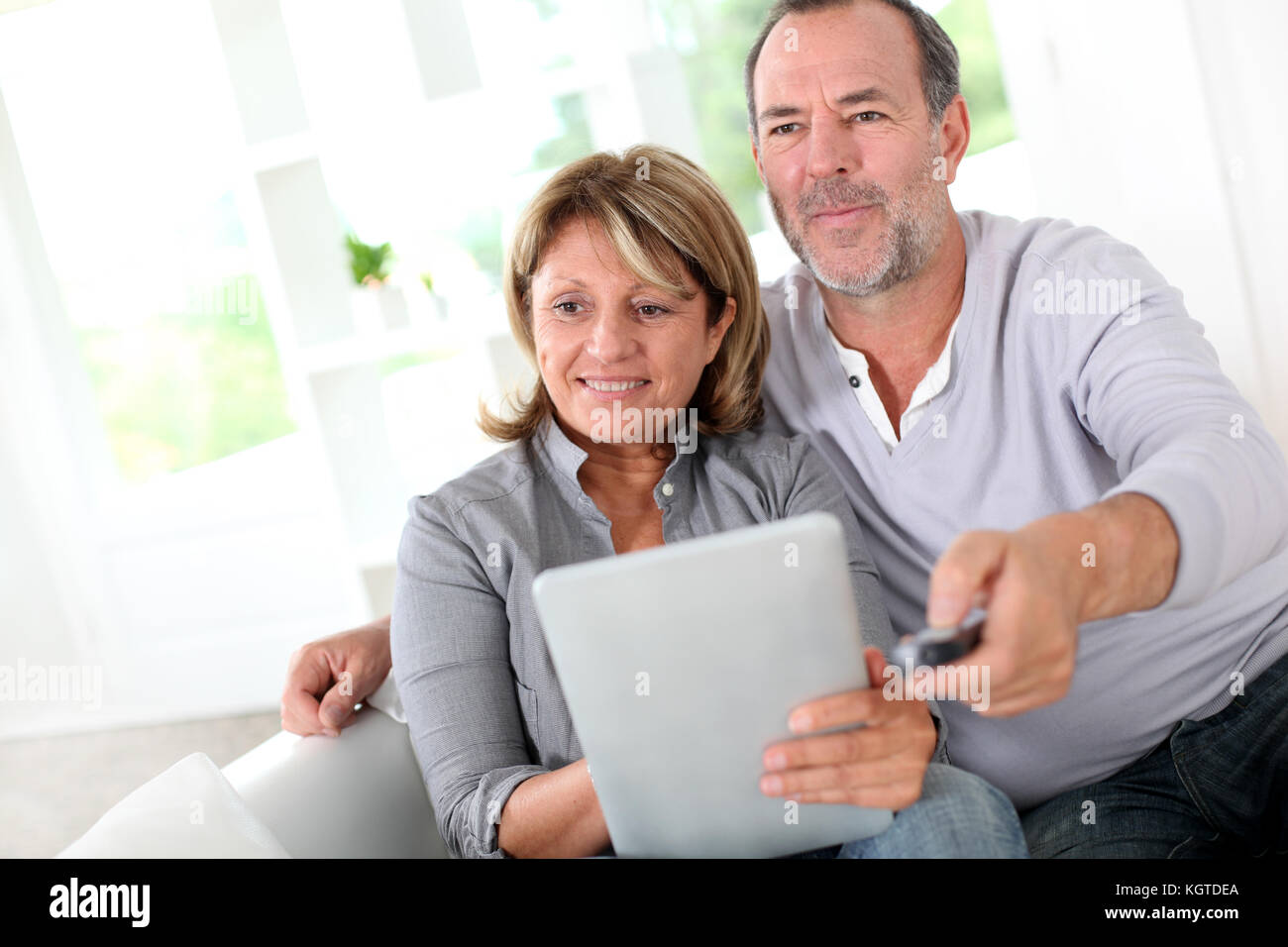 Senior married couple choosing movie on tv Stock Photo - Alamy