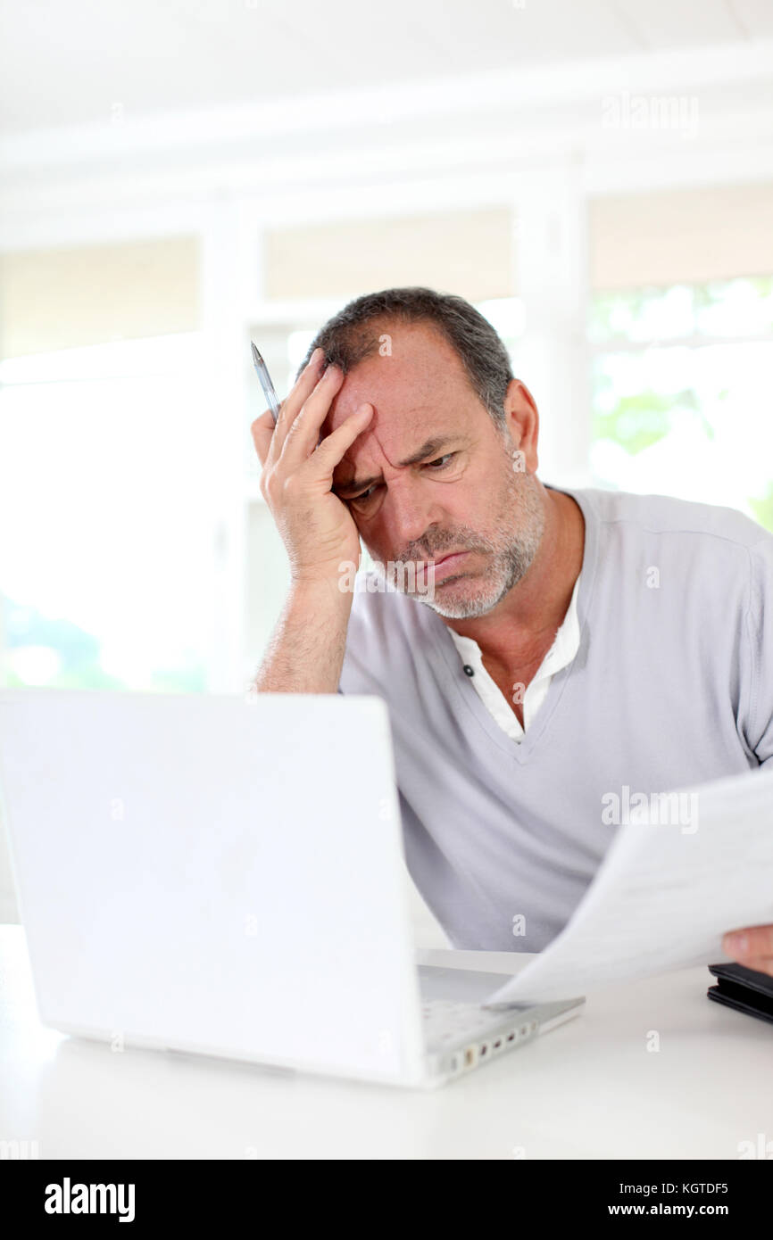 Senior man being puzzled with tax documents Stock Photo - Alamy