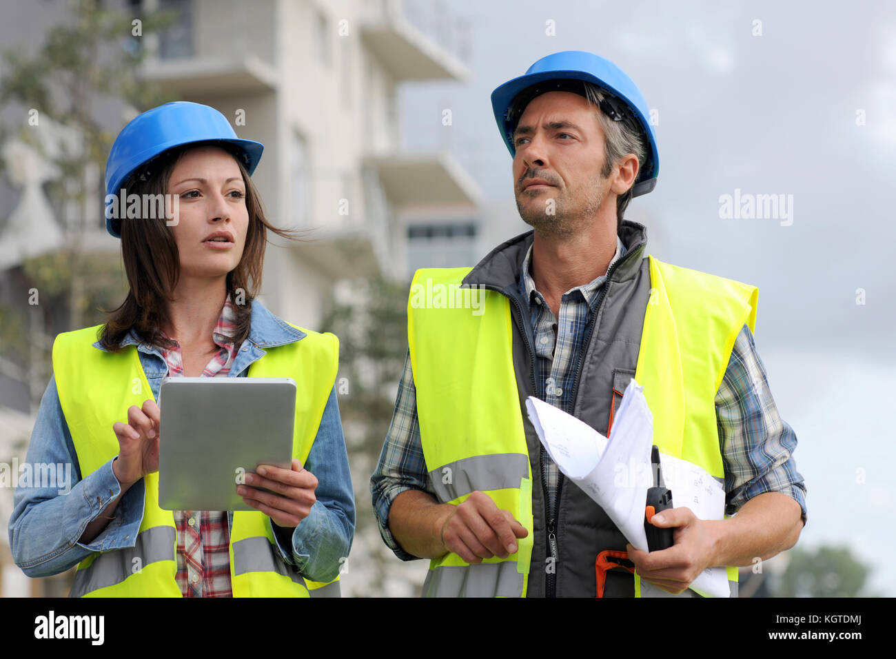 Construction people walking on building site Stock Photo - Alamy