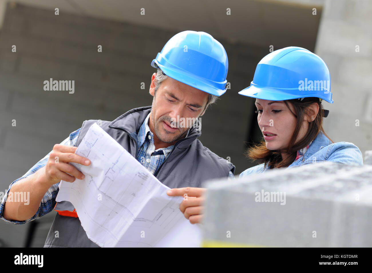 Closeup of engineers reading plan on building site Stock Photo - Alamy