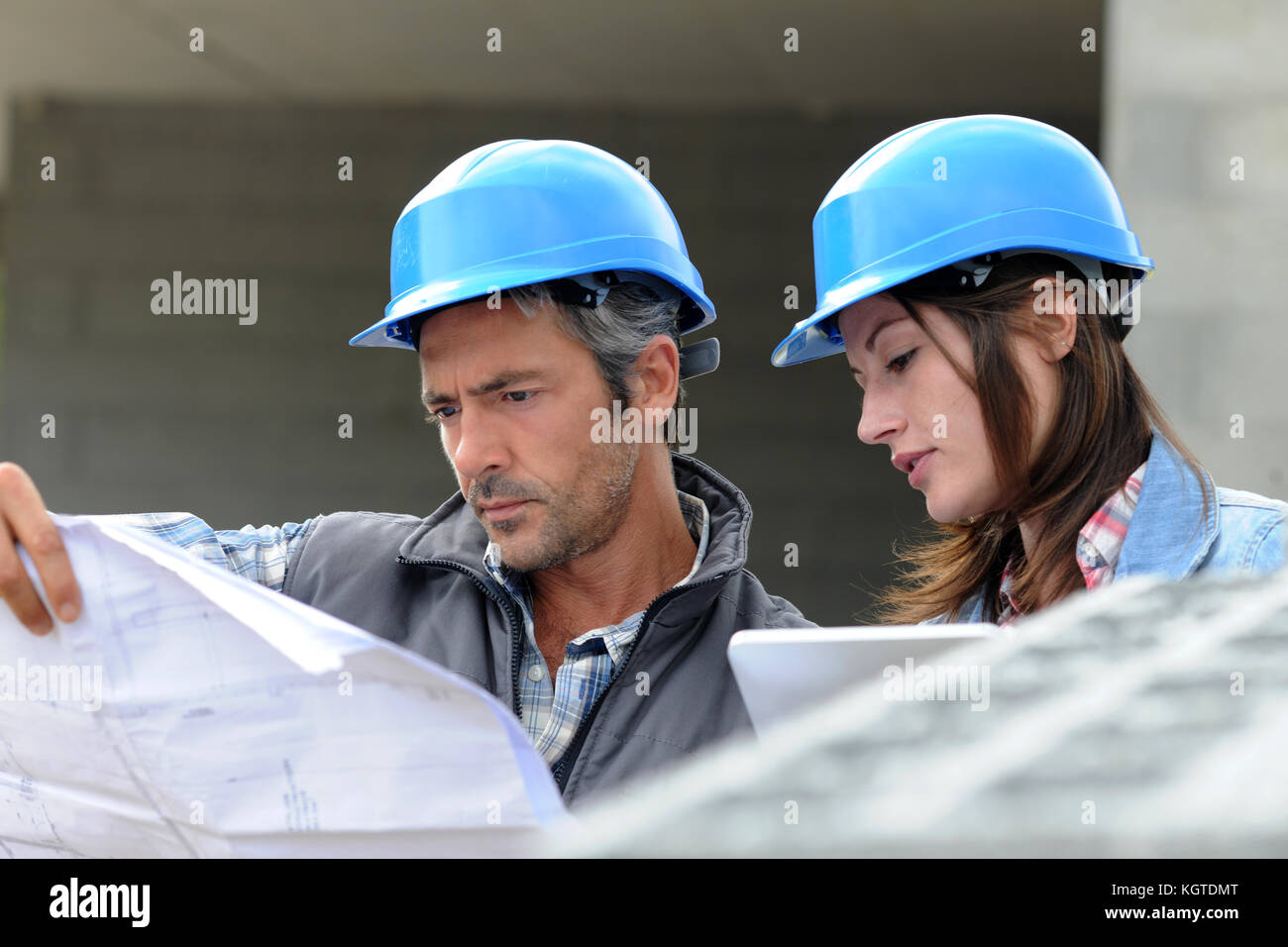 Closeup of engineers reading plan on building site Stock Photo - Alamy