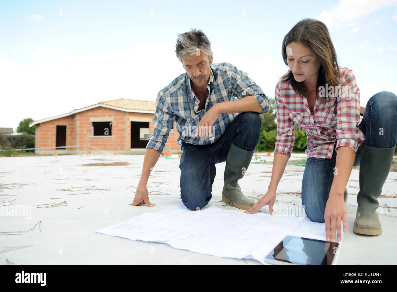 Couple checking construction plan on site Stock Photo - Alamy