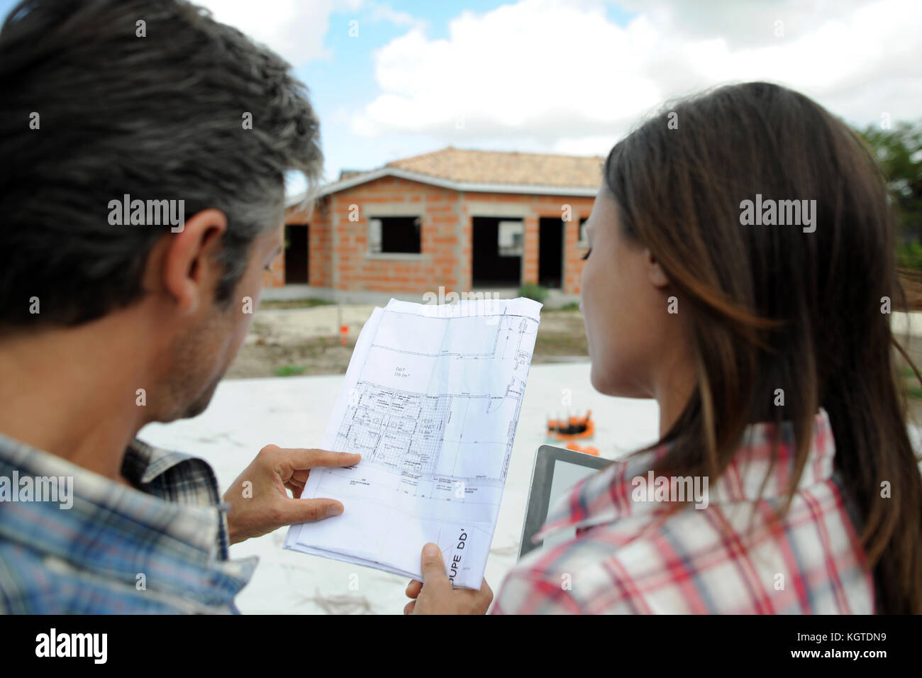 Couple standing in front of their future home Stock Photo - Alamy