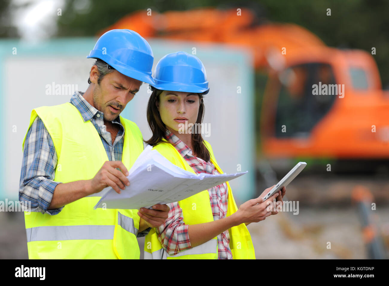 Construction people using electronic tablet on site Stock Photo - Alamy