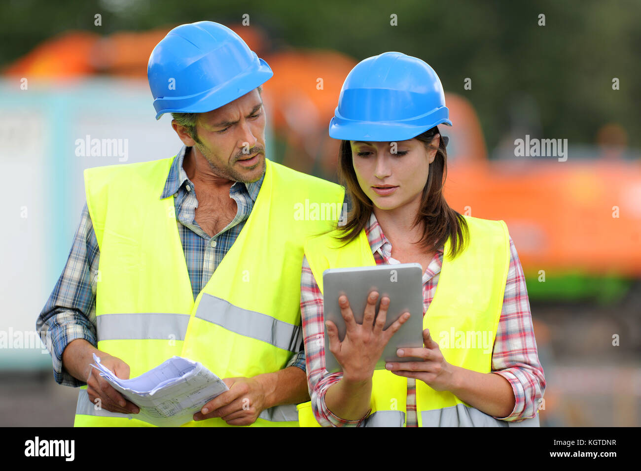 Construction people using electronic tablet on site Stock Photo - Alamy