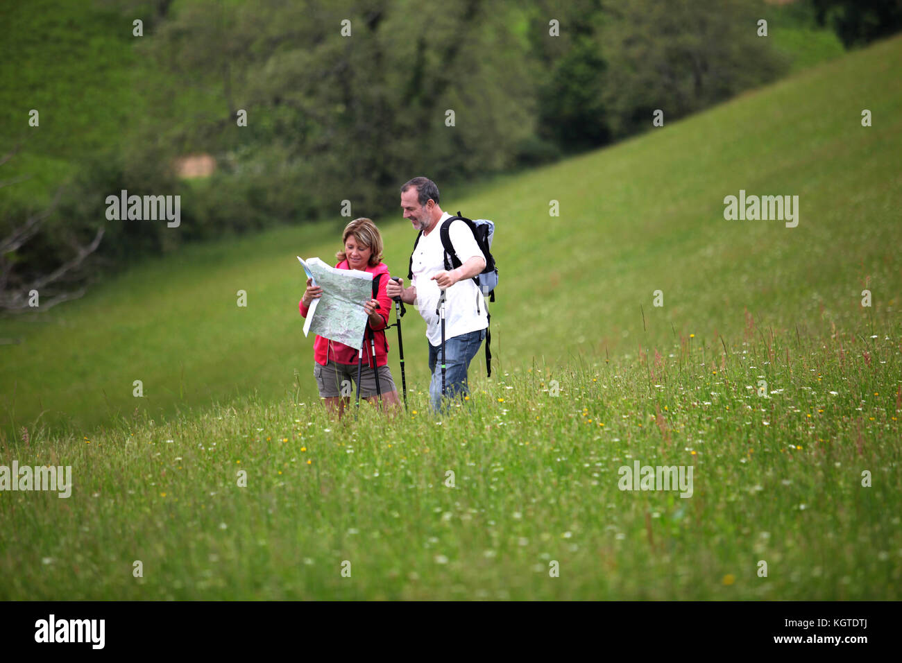 Senior hikers reading map in country field Stock Photo - Alamy