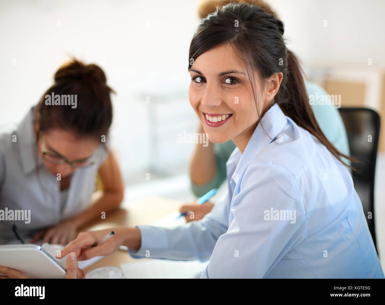 Smiling young businesswoman in business meeting Stock Photo - Alamy