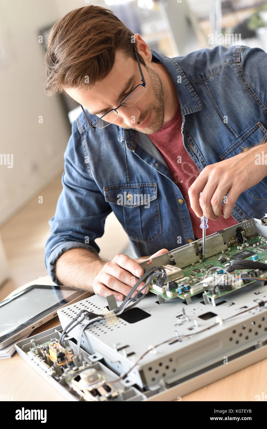 Repairman fixing tv set Stock Photo - Alamy