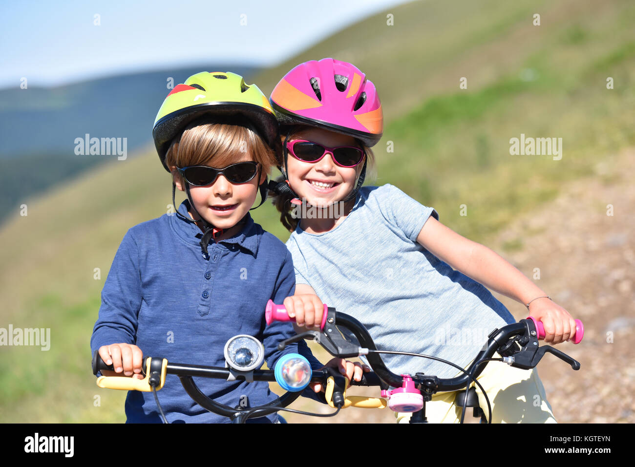 Portrait of cheerful kids riding bike Stock Photo - Alamy