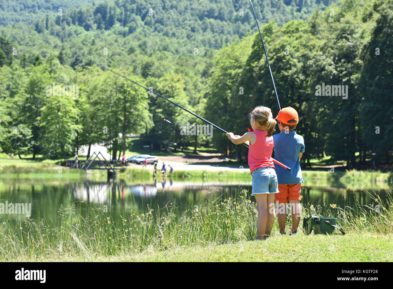 Kids fishing by mountain lake in summer Stock Photo - Alamy
