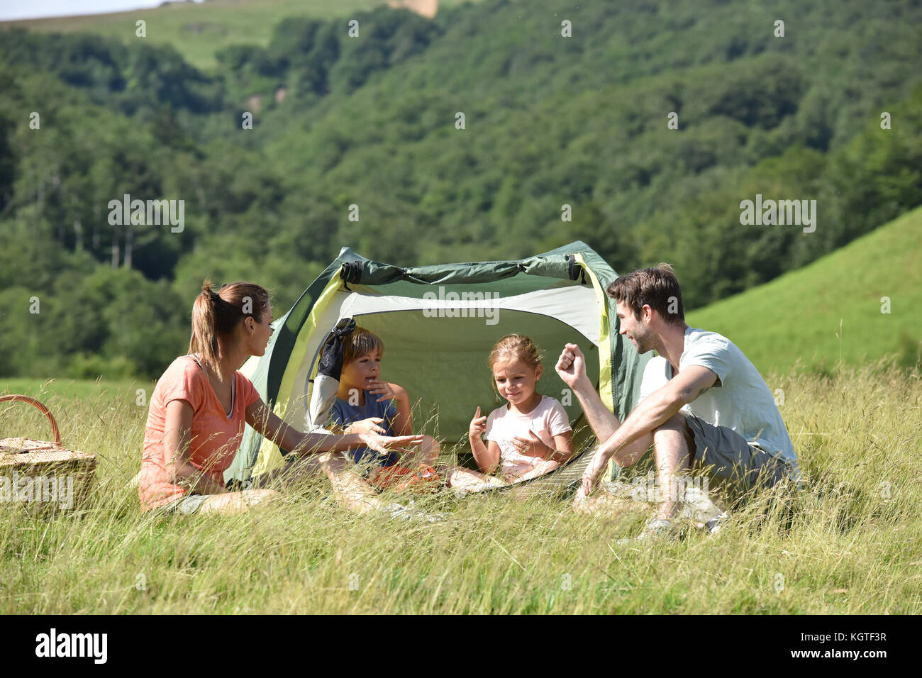 Family of four in camp tent Stock Photo - Alamy
