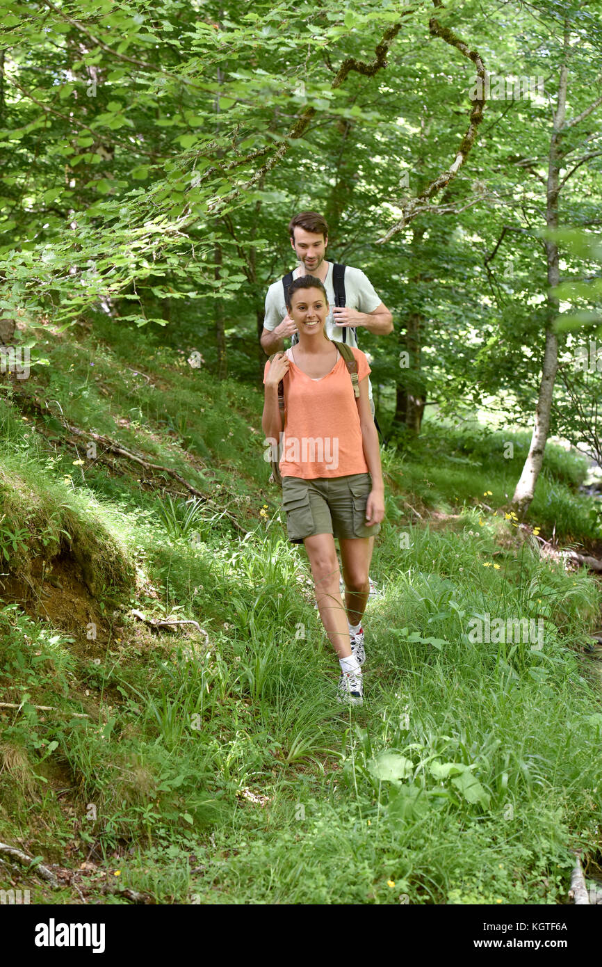 Couple rambling in forest path Stock Photo - Alamy