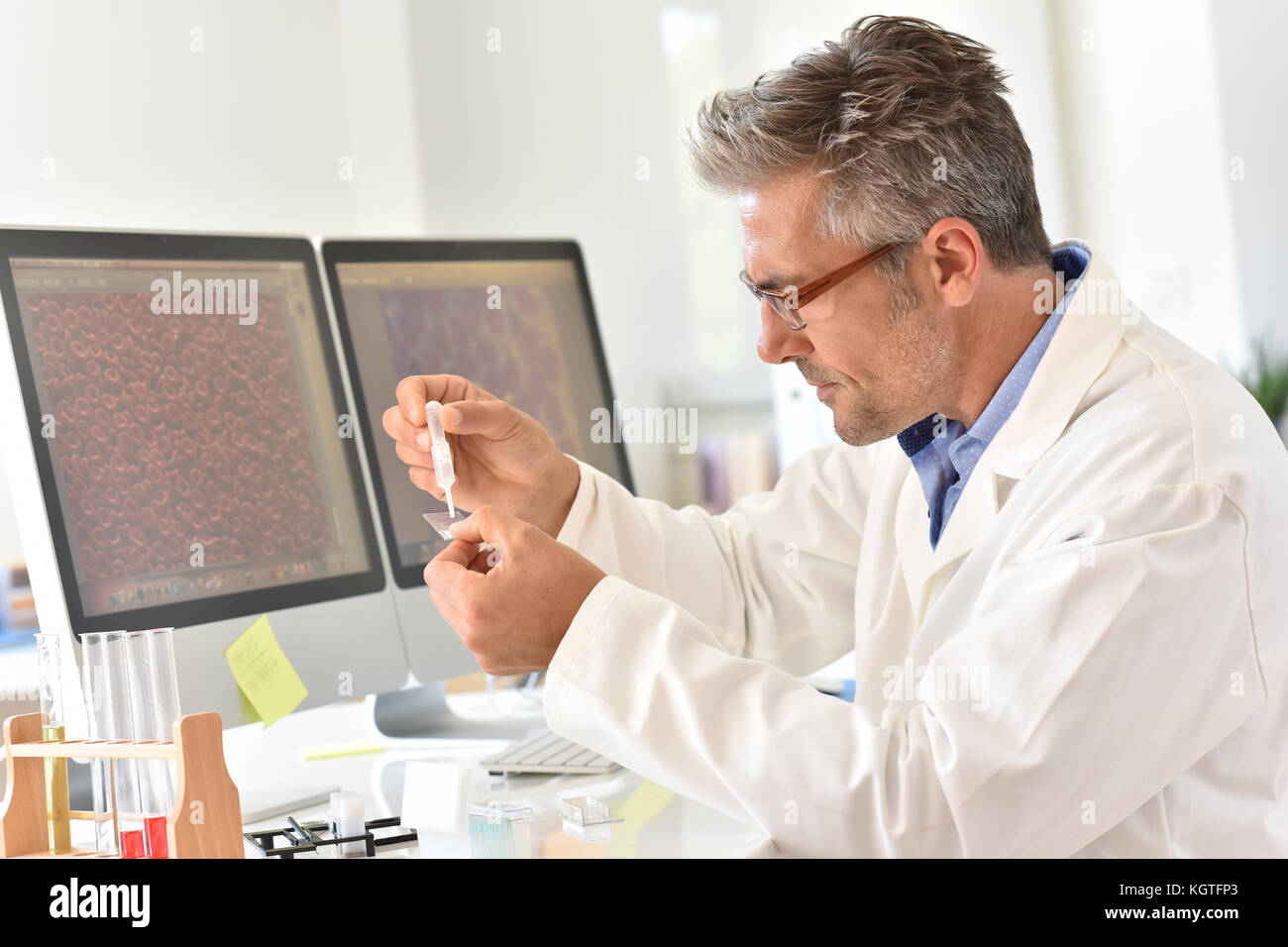 Microbiologist working on microscope in hi-res stock photography and ...