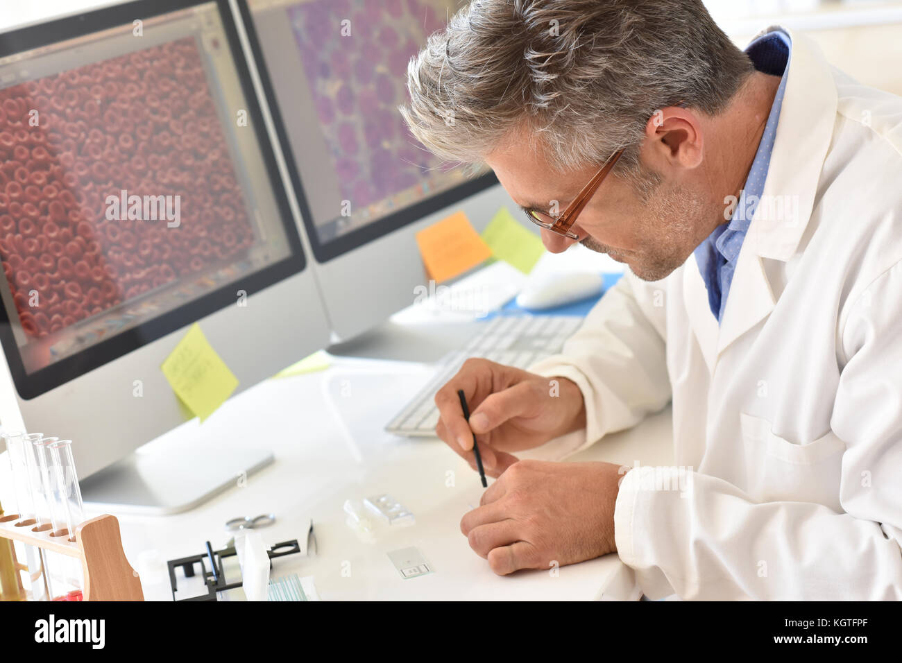 Microbiologist working on microscope in hi-res stock photography and ...