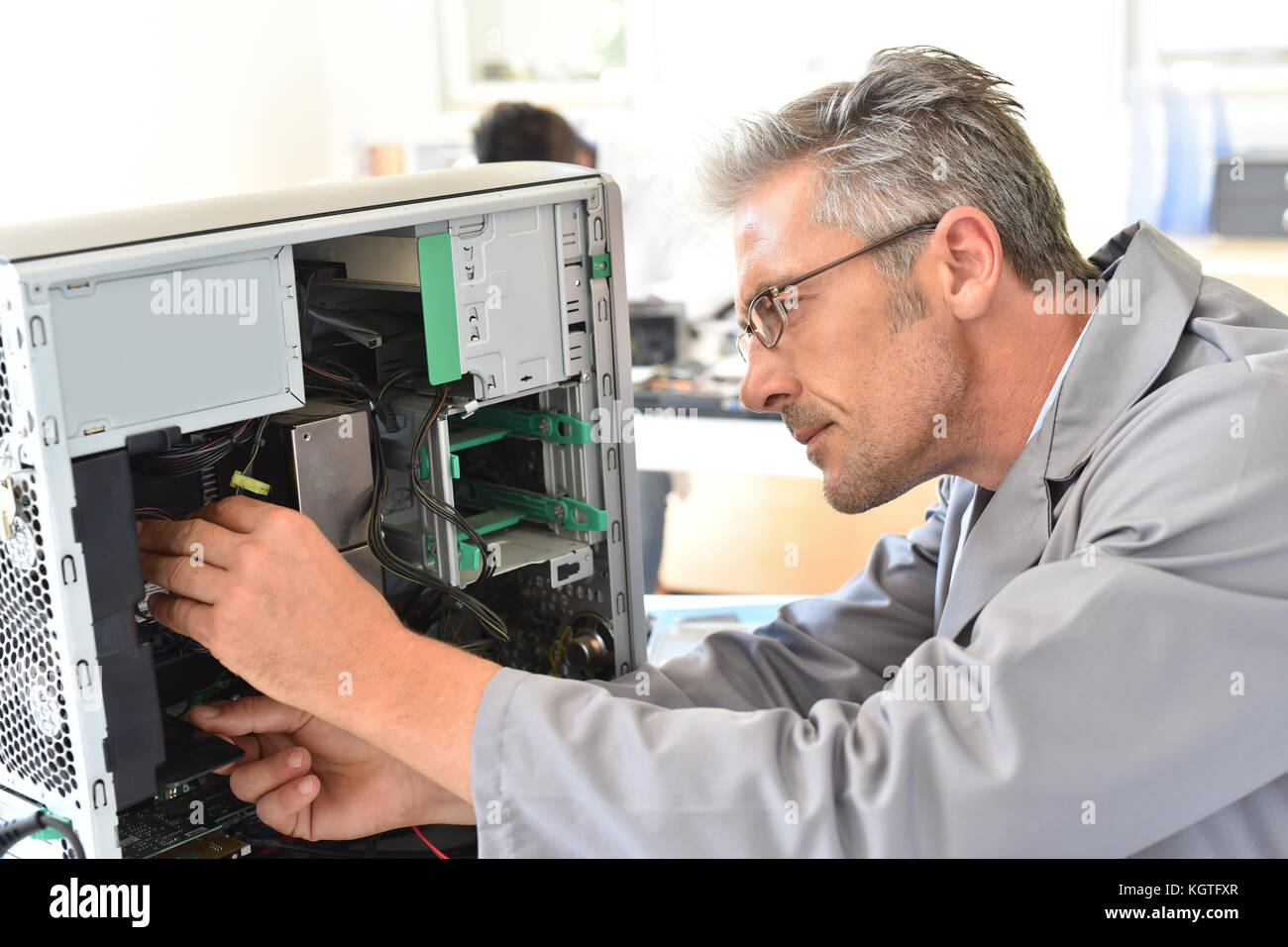 Electrical technician fixing computer hard-drive Stock Photo - Alamy