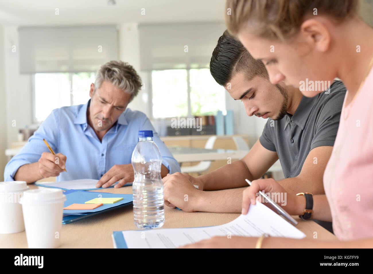 College students filling in registration forms Stock Photo - Alamy