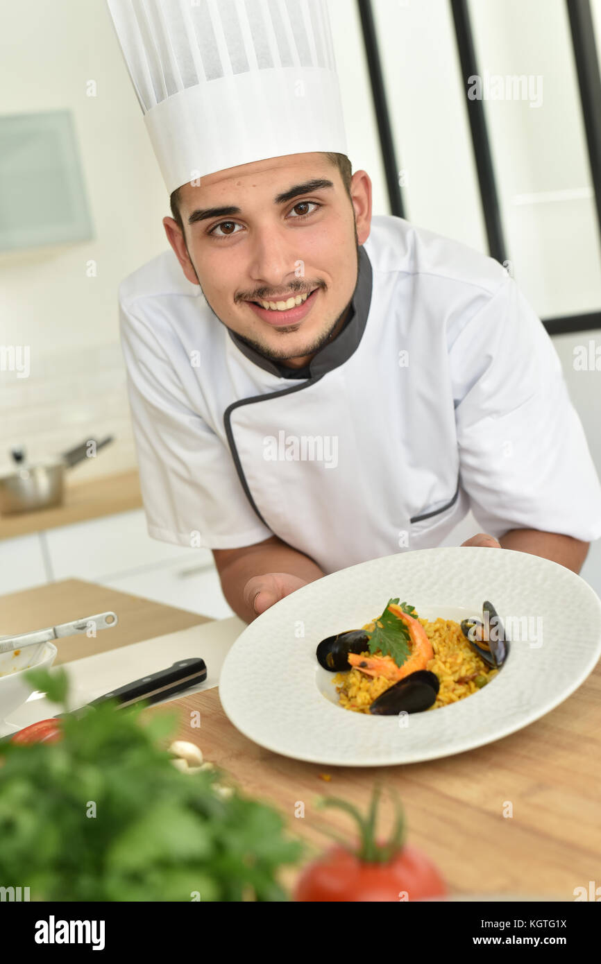 Young chef in cooking training school presenting dish Stock Photo - Alamy