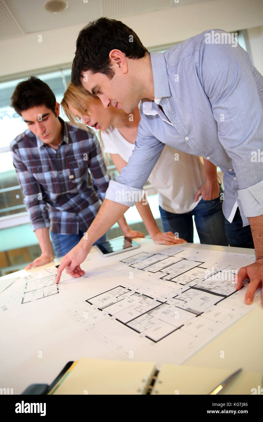Startup business team working on blueprint Stock Photo - Alamy