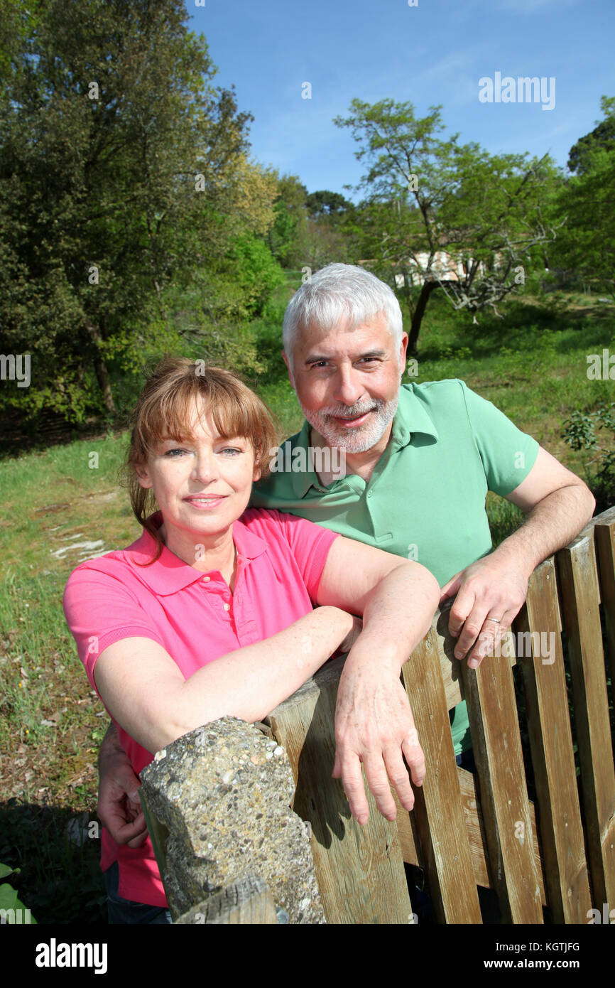 Senior couple standing by a fence Stock Photo - Alamy