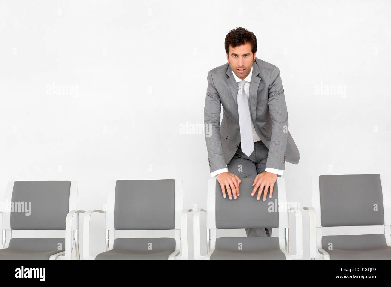 Man standing by chairs in waiting room Stock Photo - Alamy