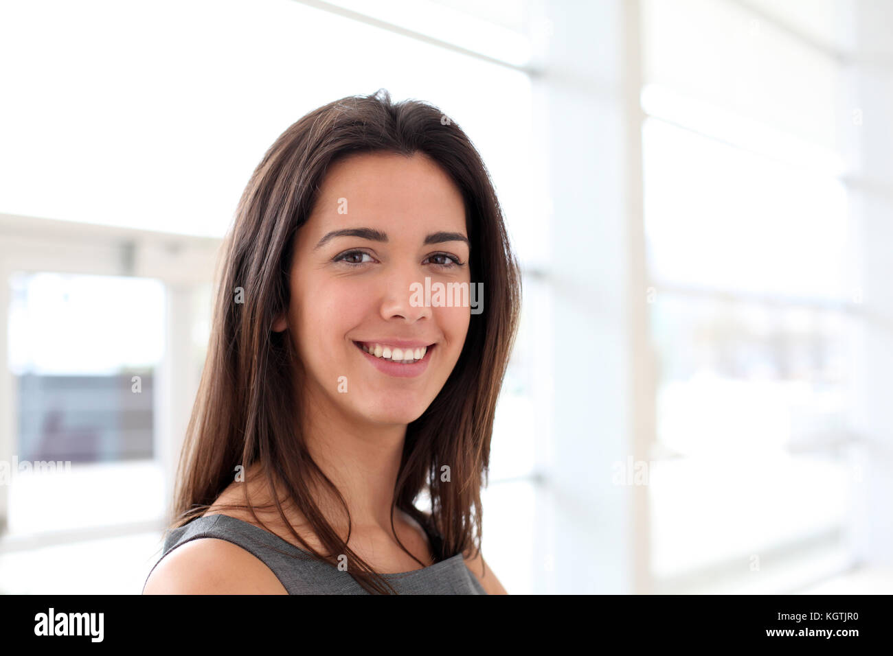 Beautiful brunette girl standing in hall Stock Photo - Alamy