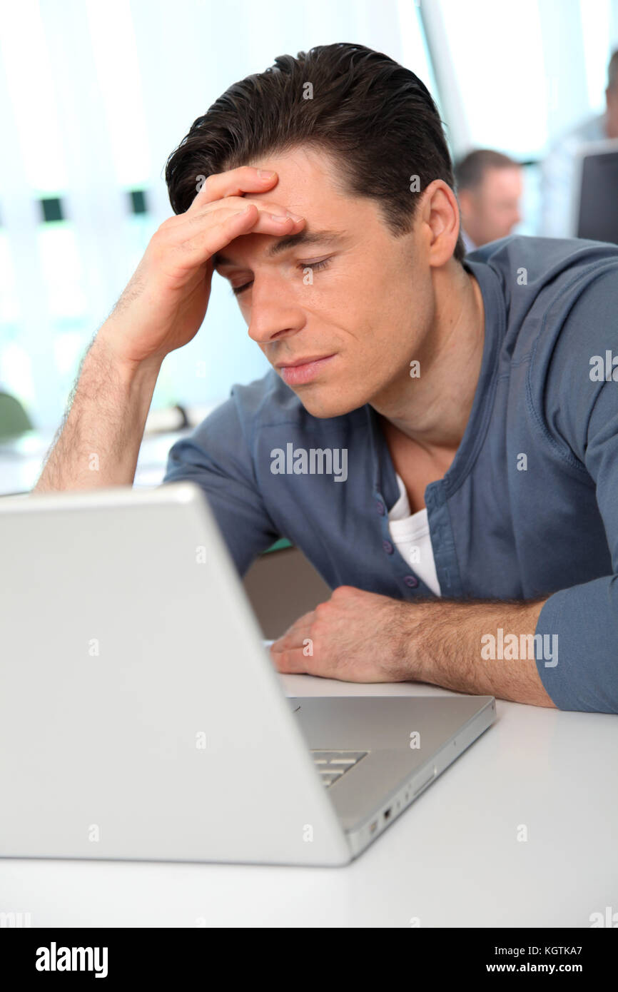 Office worker with exhausted look in front of computer Stock Photo - Alamy