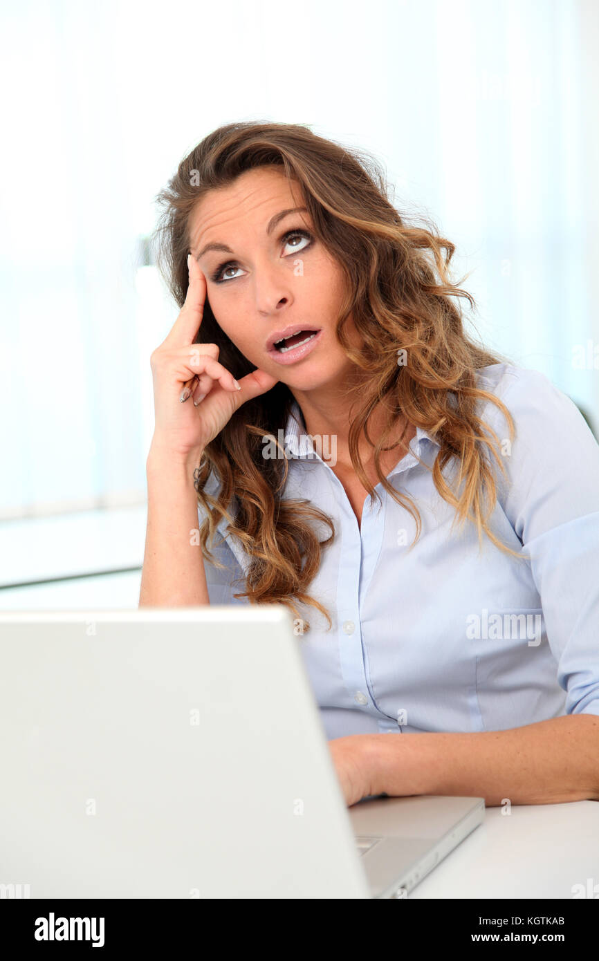 Office worker with desperate look in front of laptop Stock Photo - Alamy