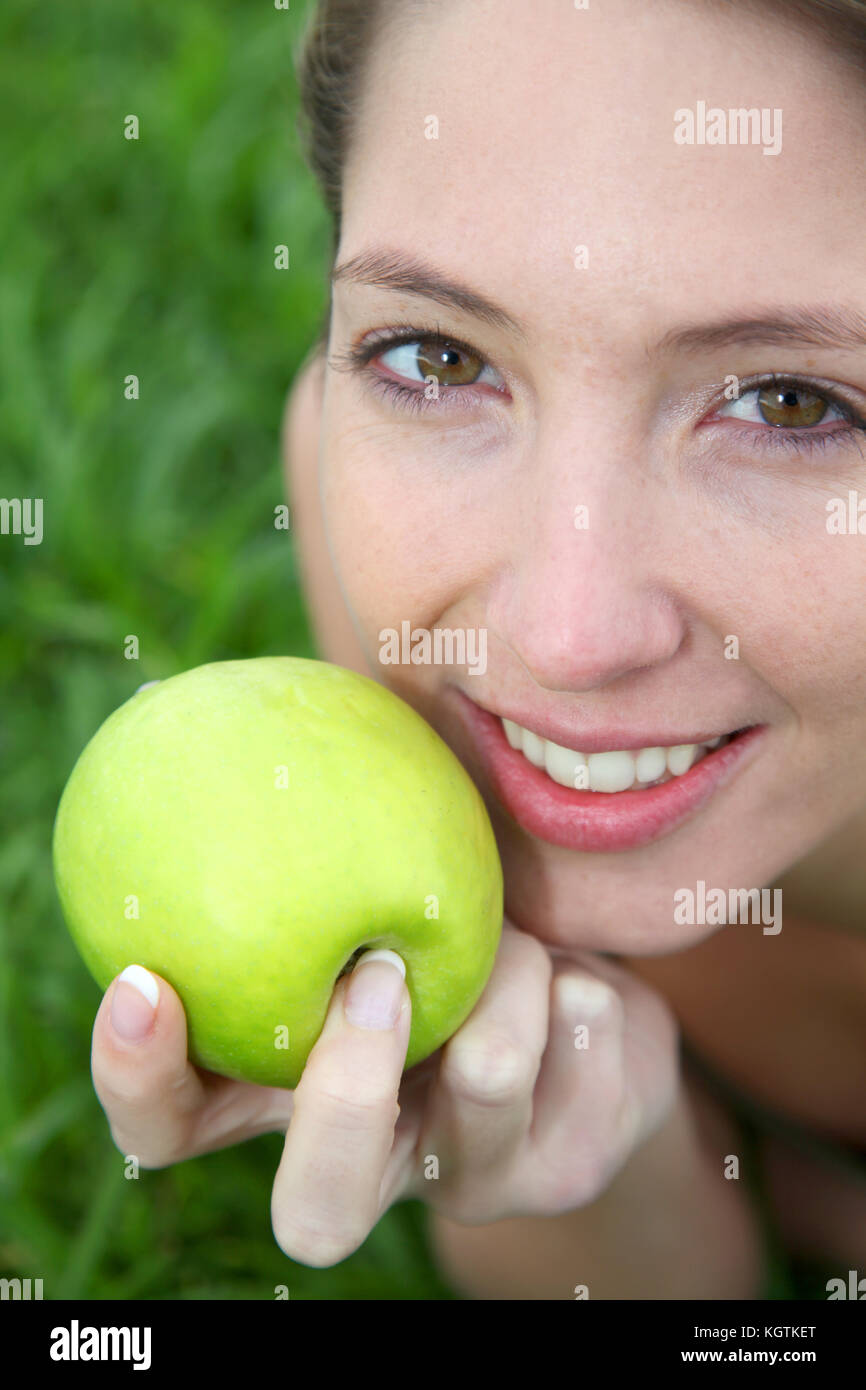 Portrait of woman eating green apple Stock Photo - Alamy