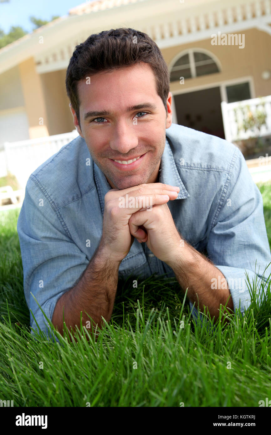 Smiling man laying down home garden Stock Photo - Alamy