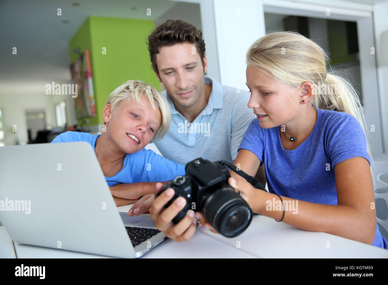Man with teenagers looking at pictures on computer Stock Photo - Alamy