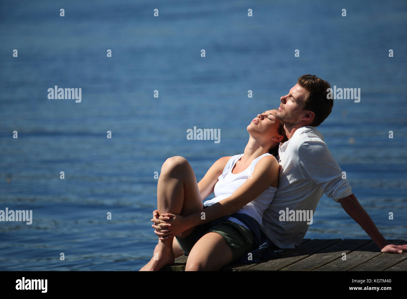Couple relaxing on a lake bridge in summertime Stock Photo - Alamy