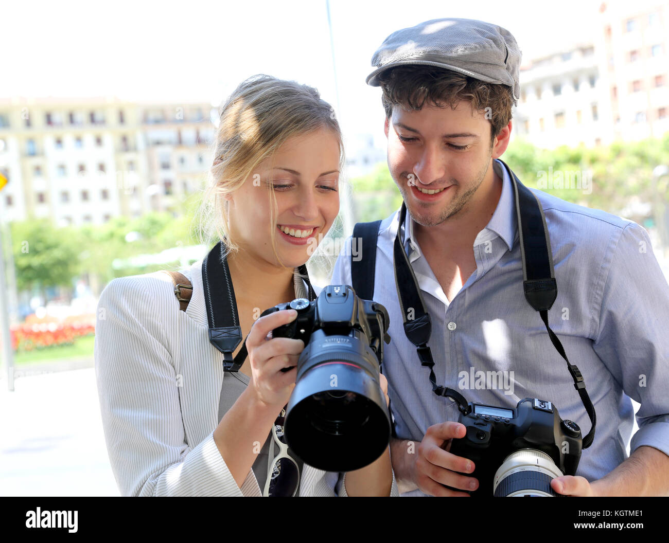 Couple of photographers looking at snapshots Stock Photo - Alamy