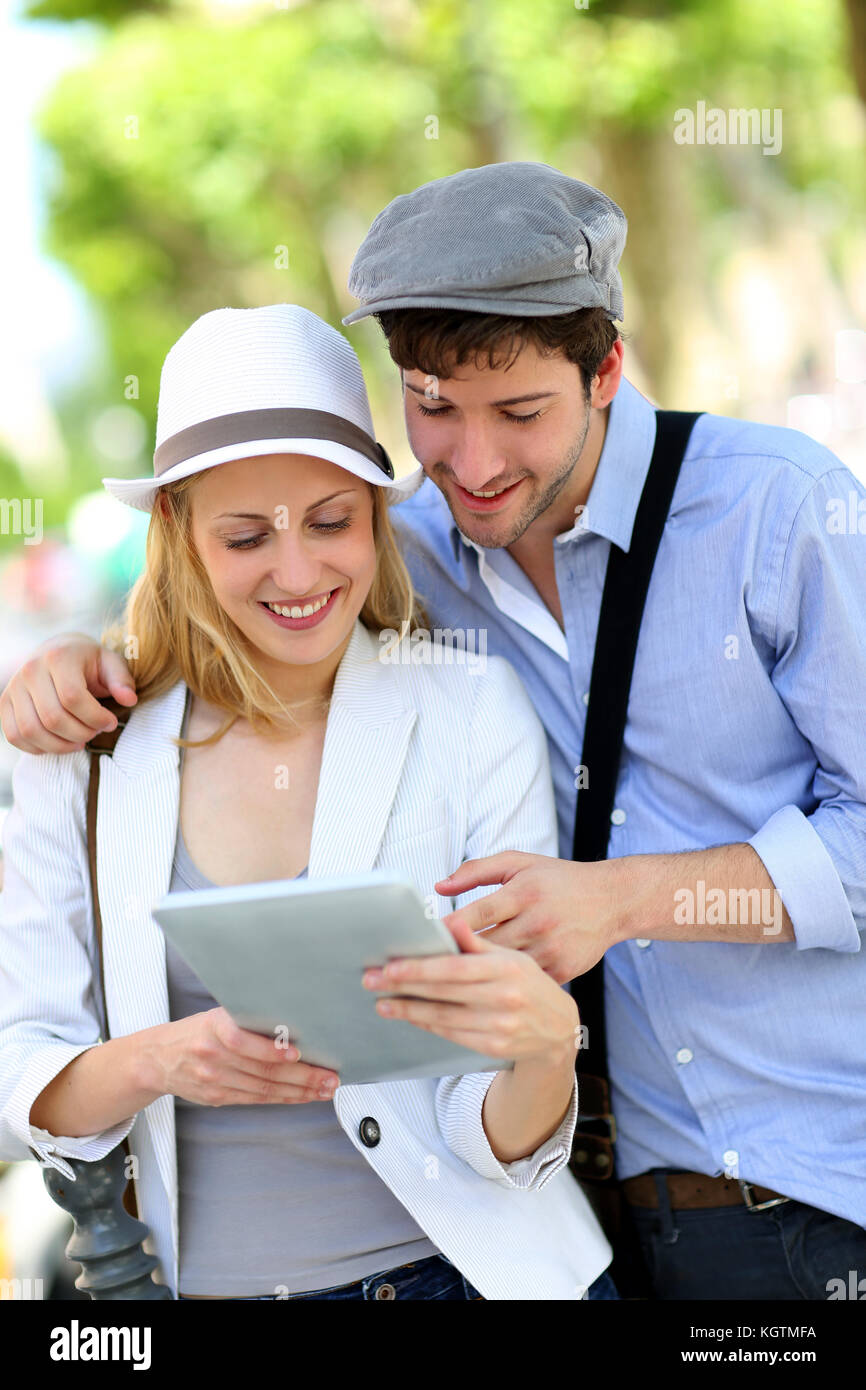 Young couple in town using electronic tablet Stock Photo - Alamy