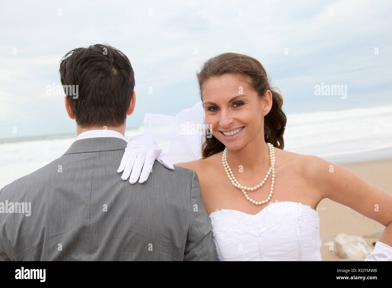 Smiling bride standing on a sandy beach Stock Photo - Alamy