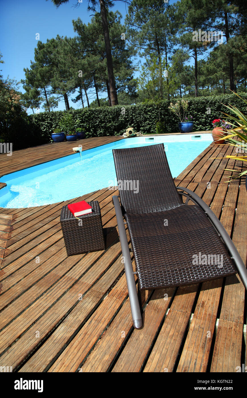 View of long chairs set by swimming pool Stock Photo - Alamy