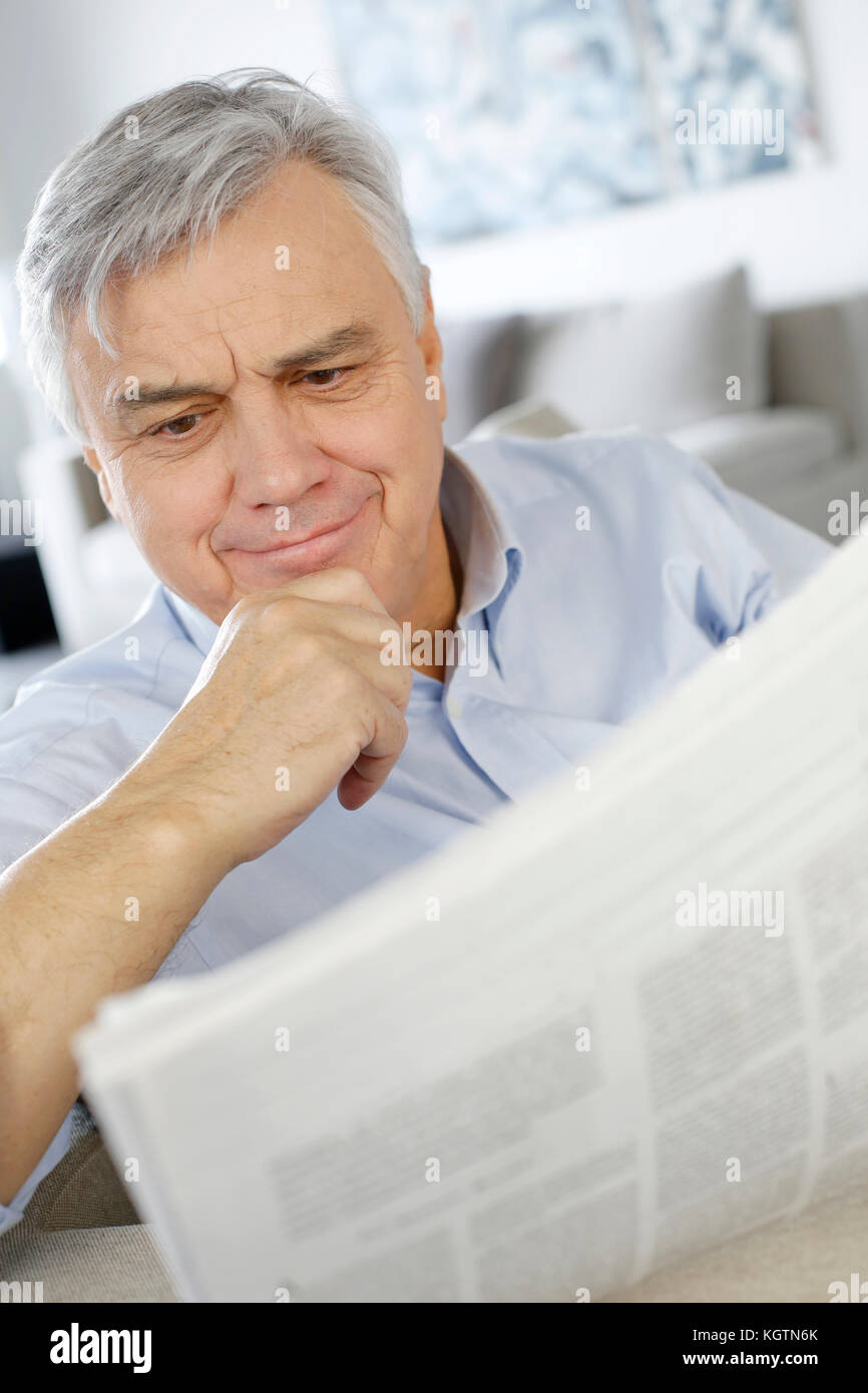 Senior man reading news with perplexed look Stock Photo - Alamy