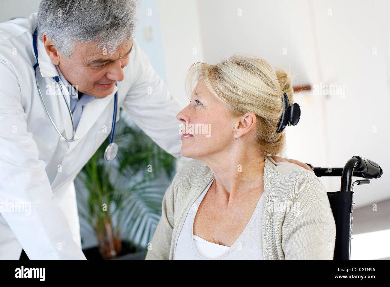 Portrait of surgeon talking to patient in wheelchair Stock Photo - Alamy