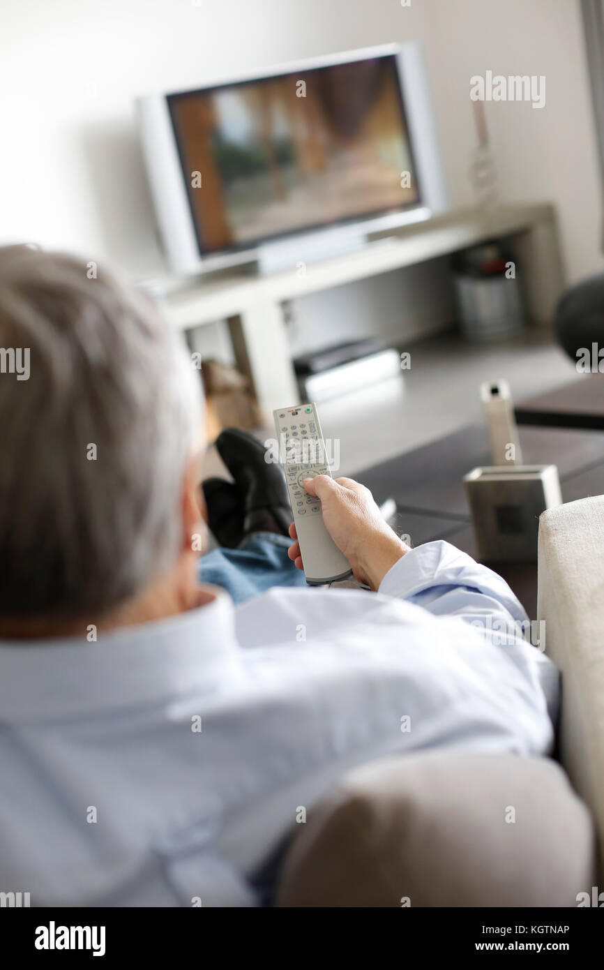 Back view of senior man in couch watching tv Stock Photo - Alamy