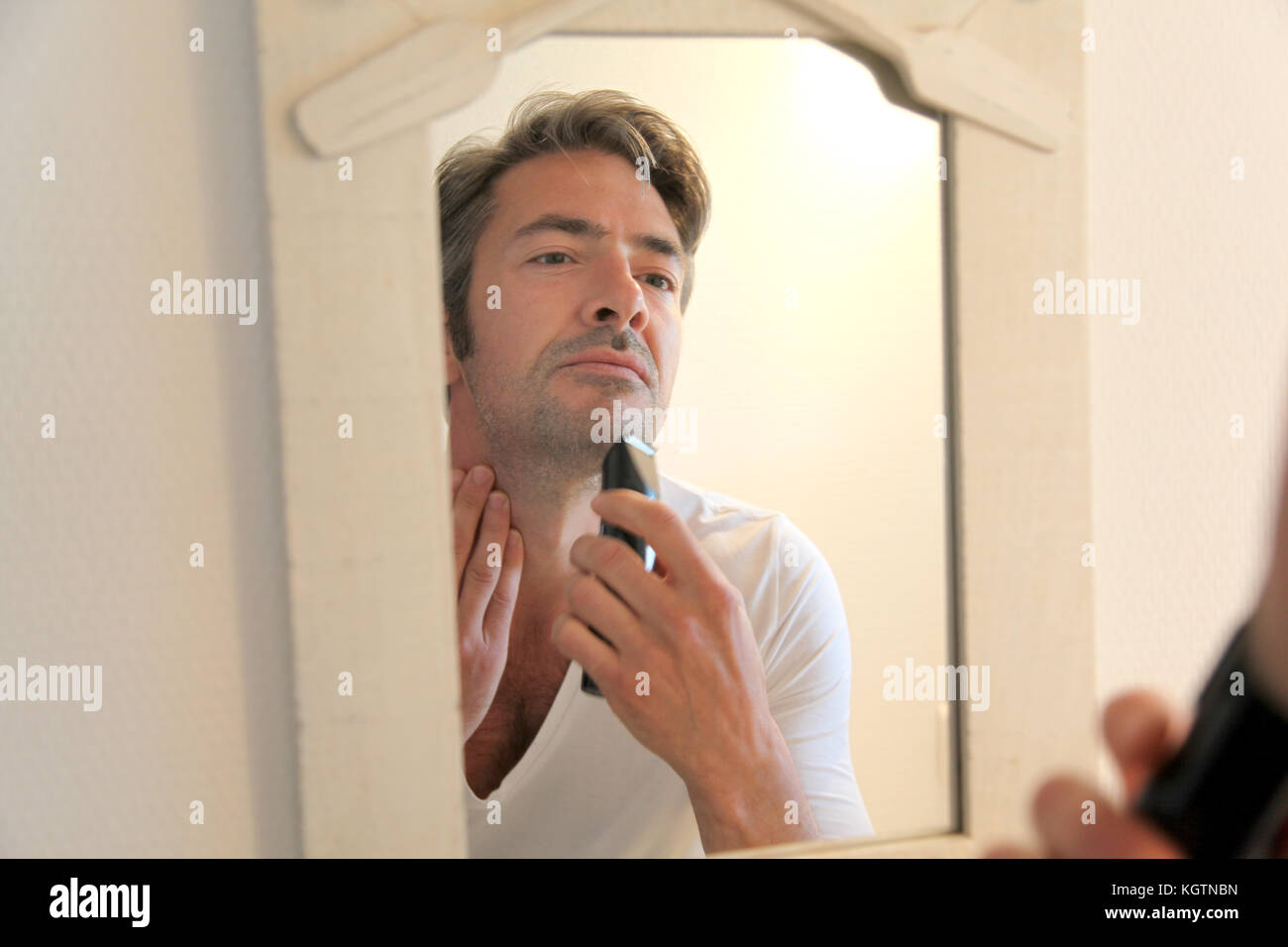 Portrait of man using electric razor Stock Photo - Alamy