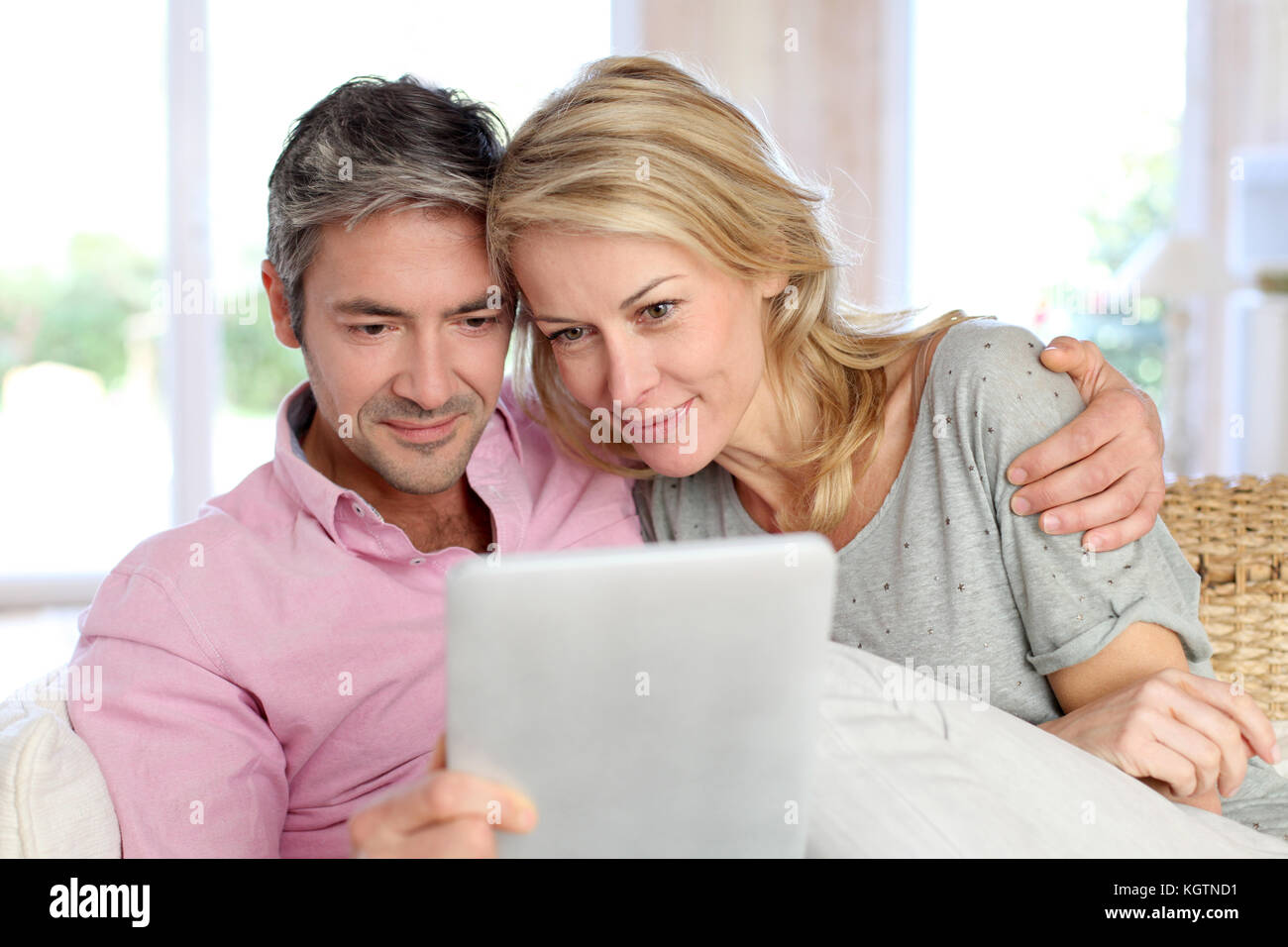 Couple at home using electronic tablet Stock Photo - Alamy