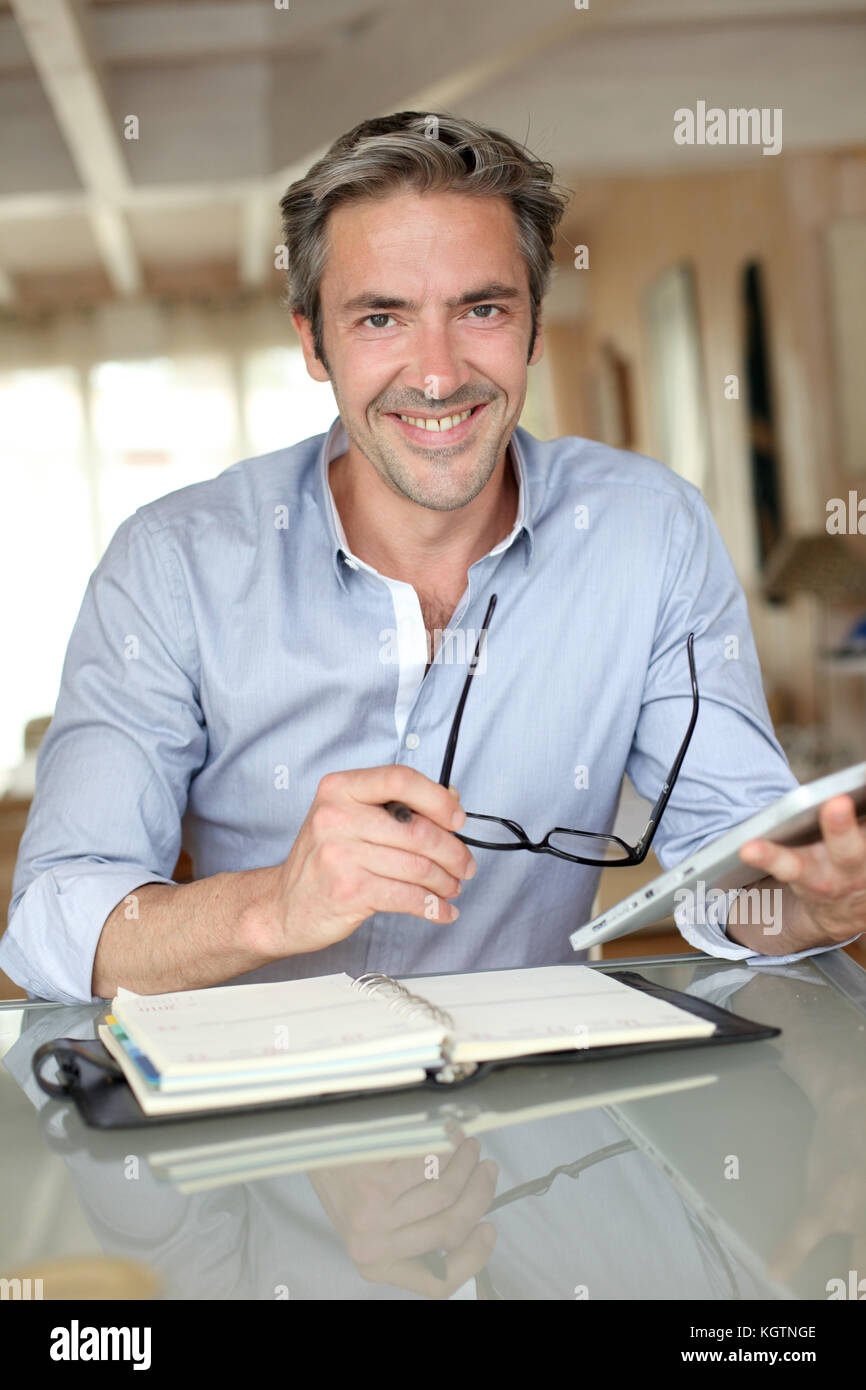 Handsome guy working from home with electronic tablet Stock Photo - Alamy