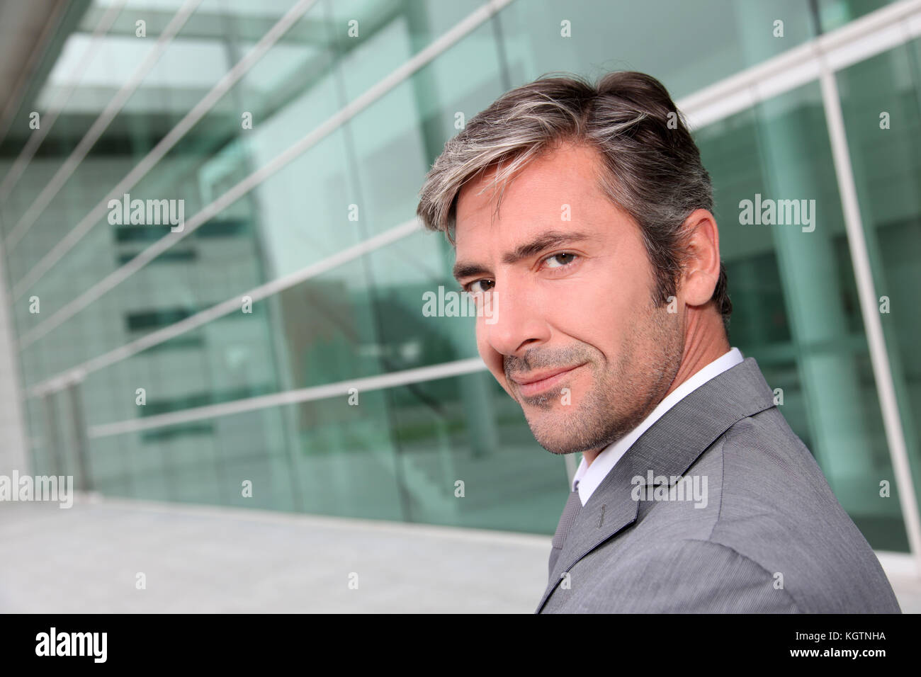 Portrait of businessman standing in front of modern building Stock ...