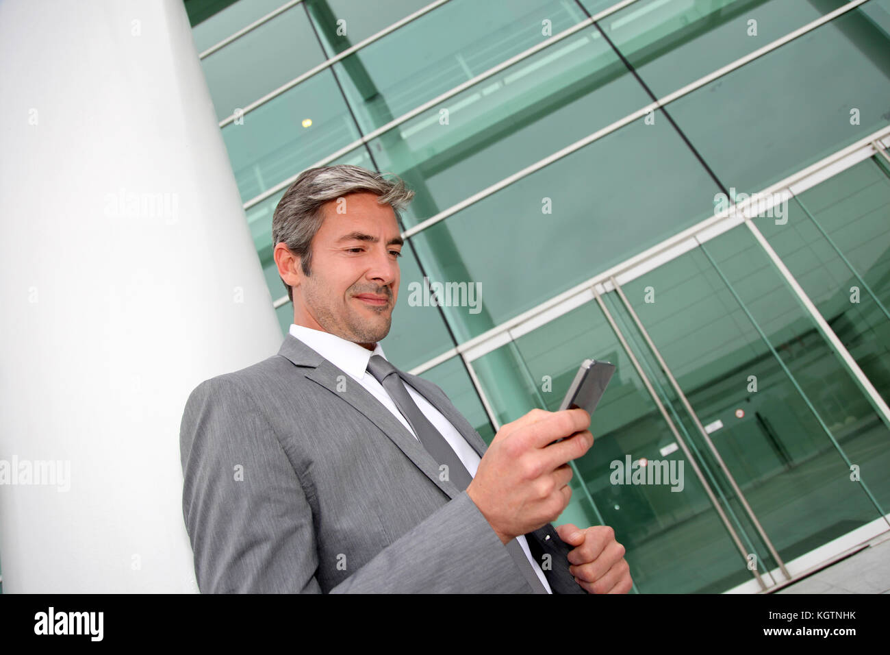 Businessman writing short message on mobile phone Stock Photo - Alamy