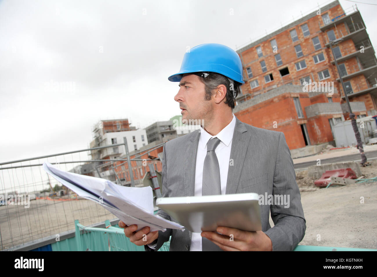 Architect checking plan of construction with tablet Stock Photo - Alamy